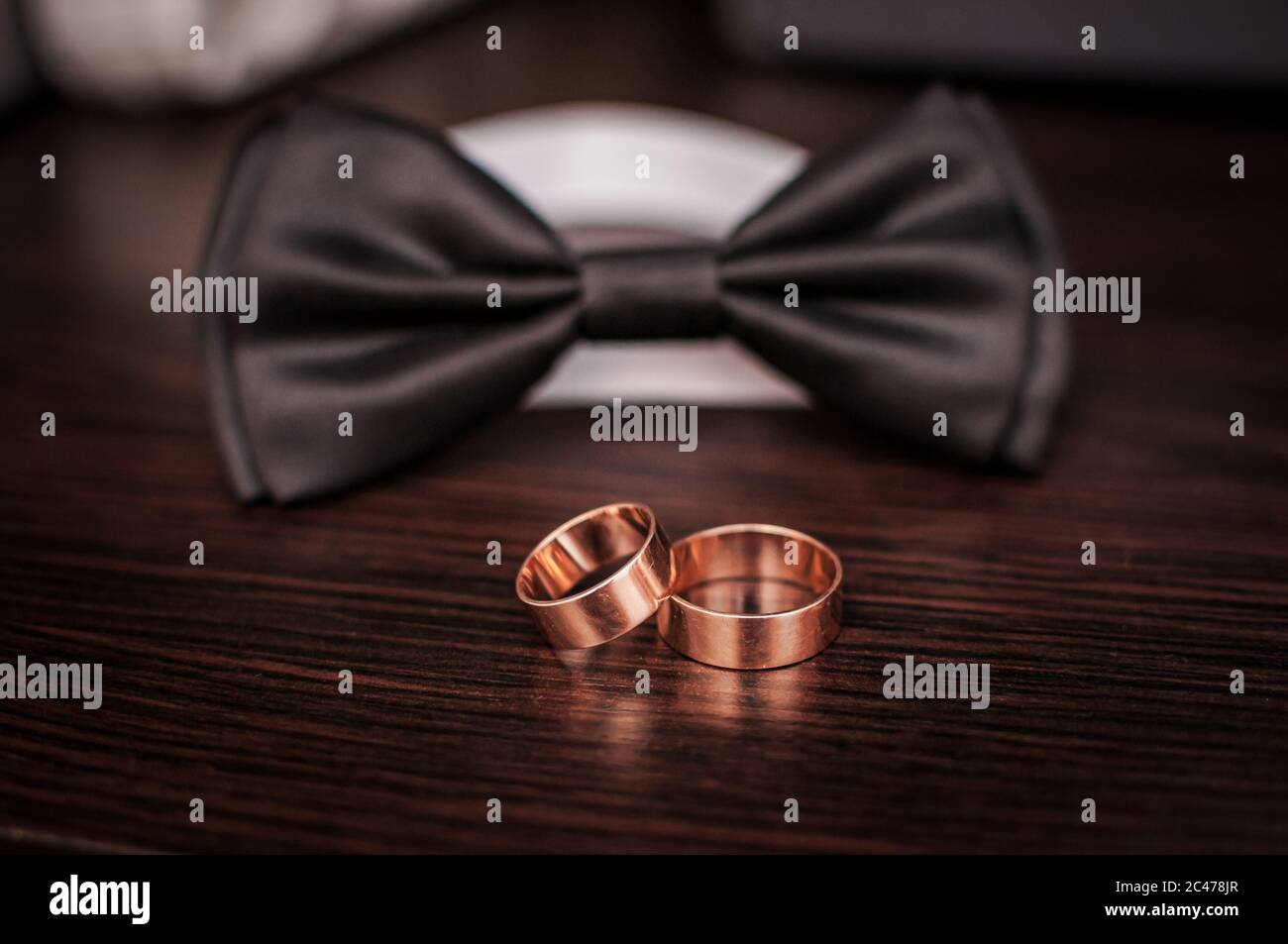 Pair of gold wedding rings and neck tie on the table Stock Photo - Alamy