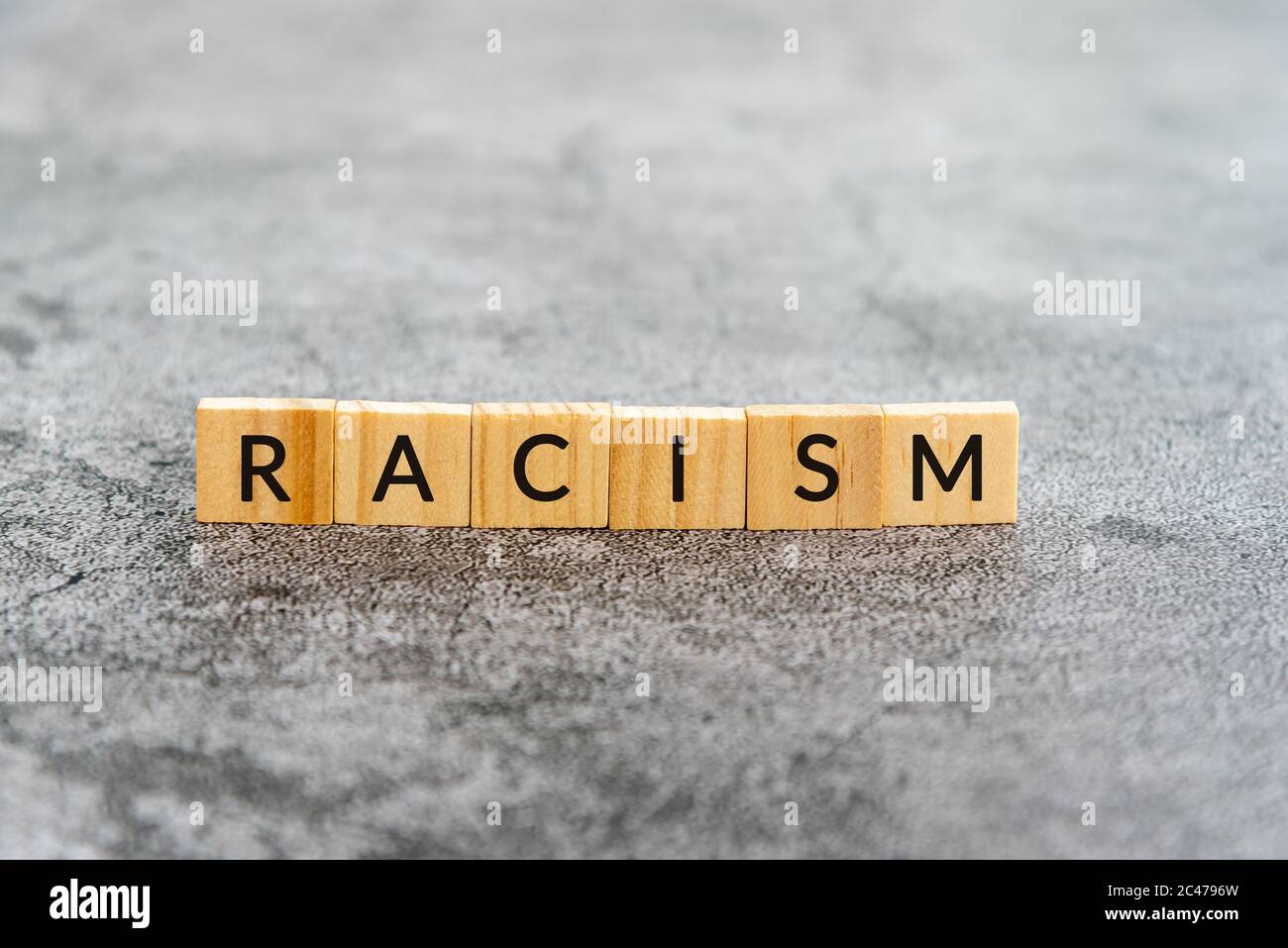 Racism text on wooden block textures background Stock Photo - Alamy