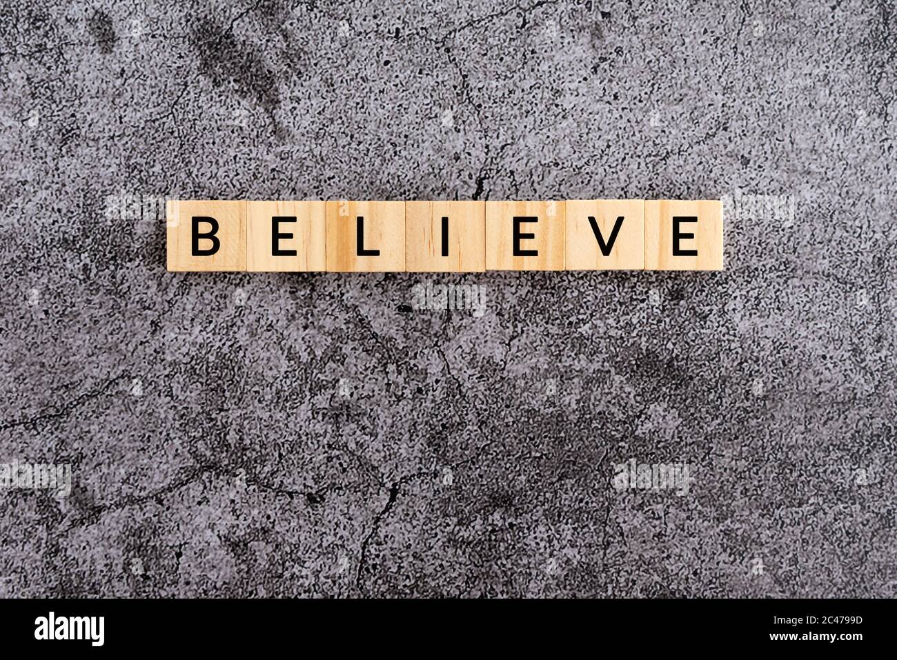 Believe text on wooden block textures background Stock Photo - Alamy