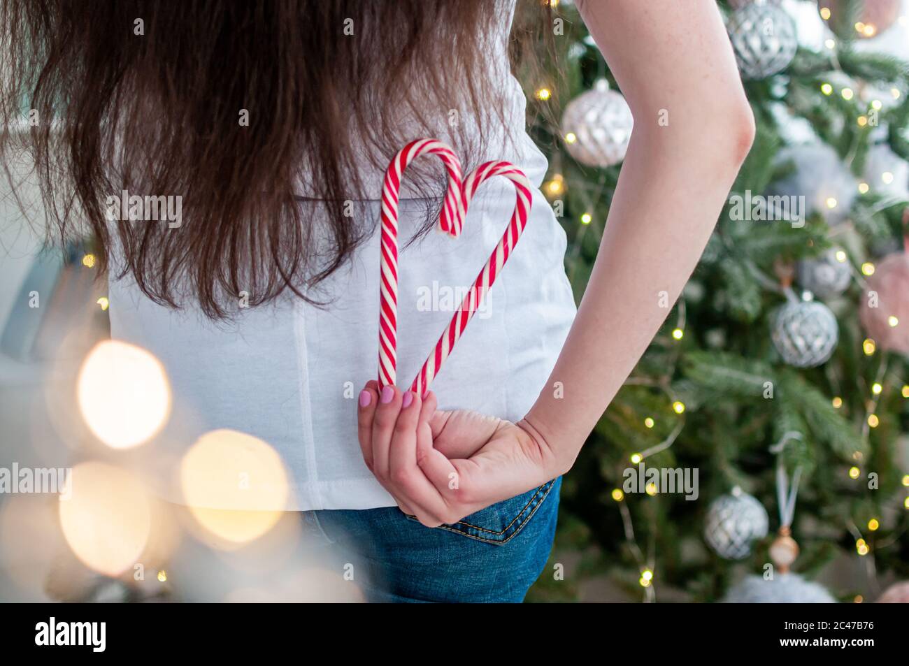 Girl holding love heart from Santa Claus cane Stock Photo - Alamy