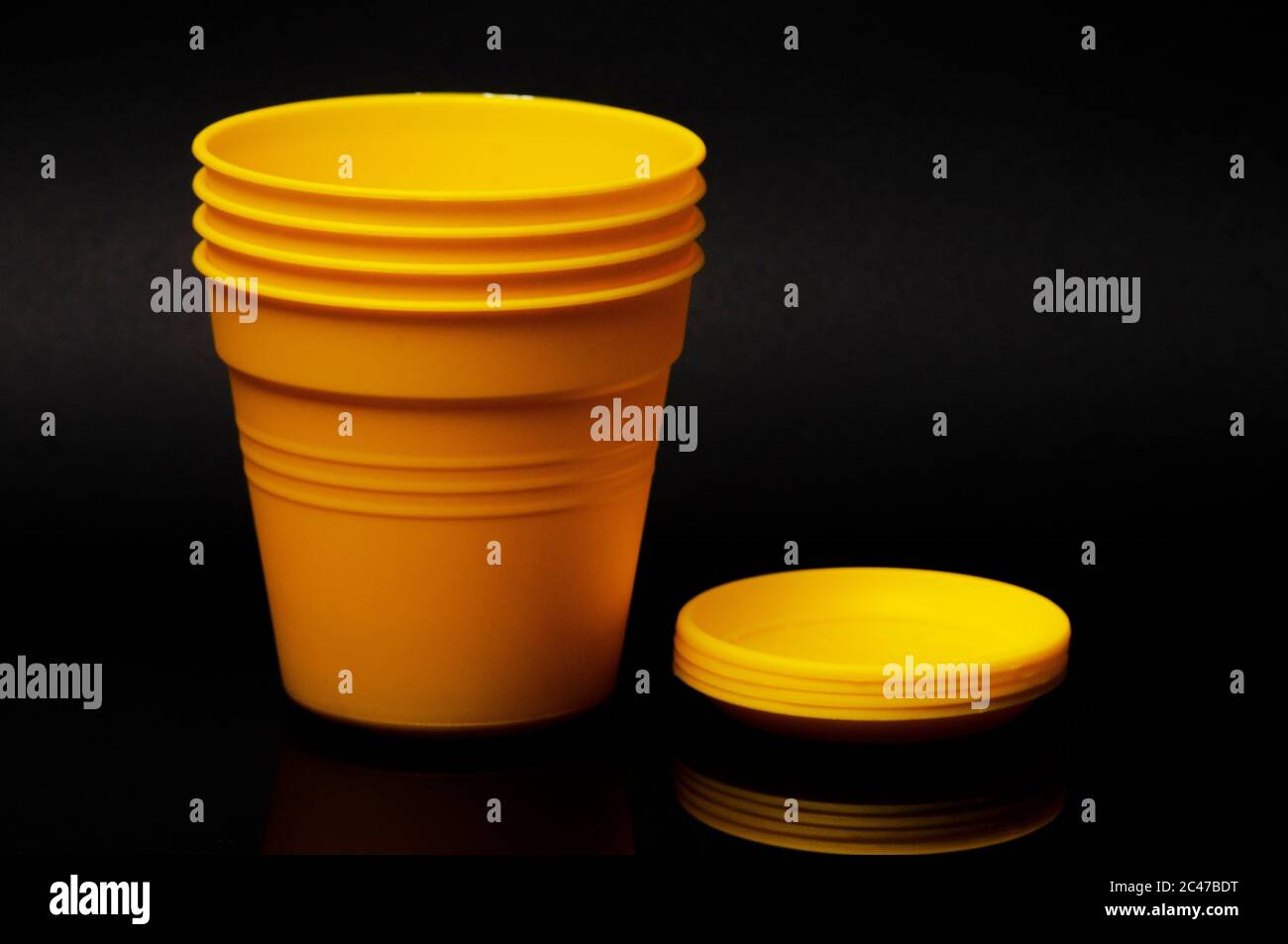 Yellow flower pot with stand on the black background Stock Photo - Alamy
