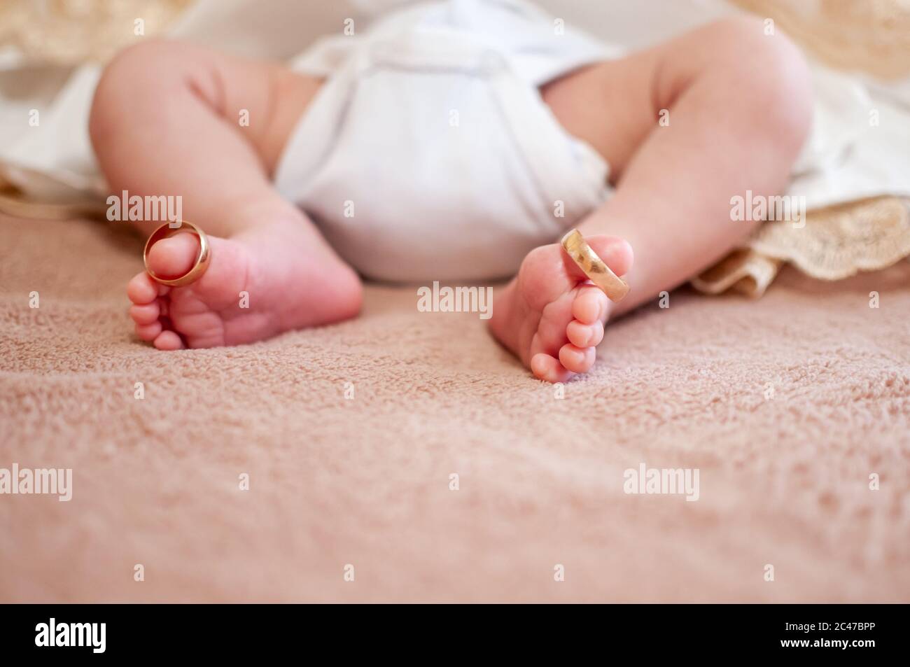 Golden rings on the big fingers of the newborn child Stock Photo - Alamy