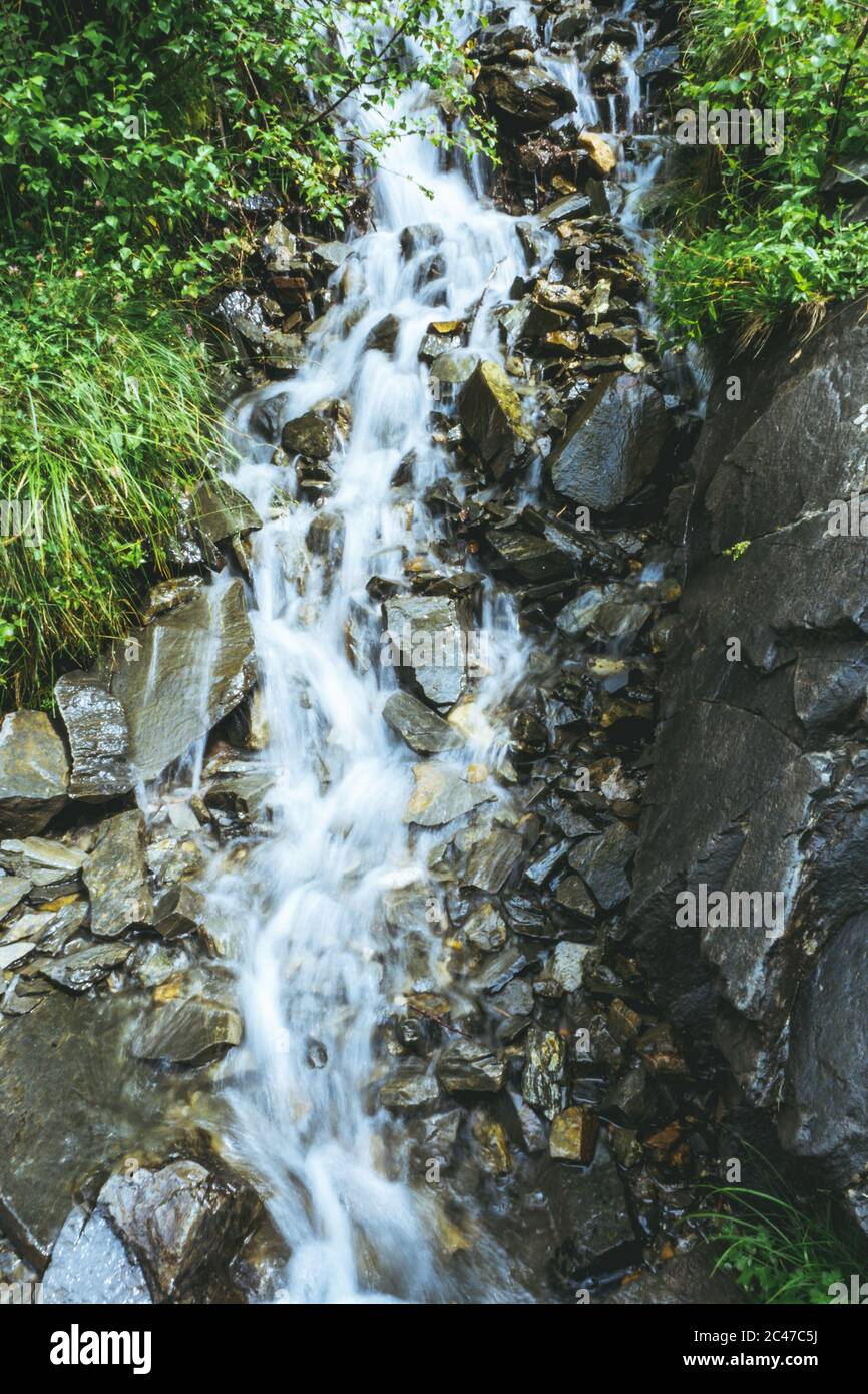 Beautiful scenery of a waterfall flowing over rock formations in a ...