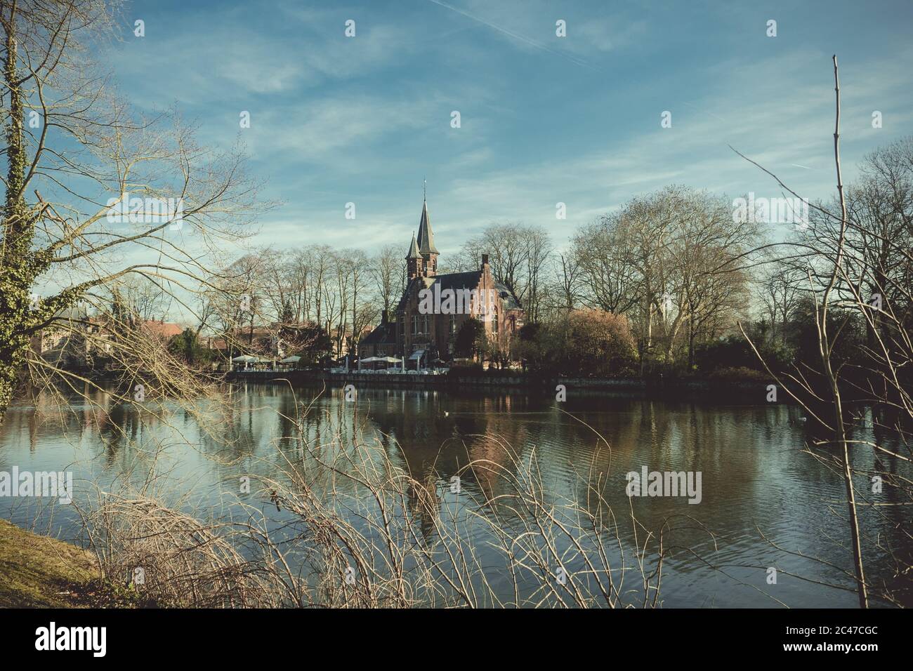 Building surrounded by trees in front of the water Stock Photo - Alamy