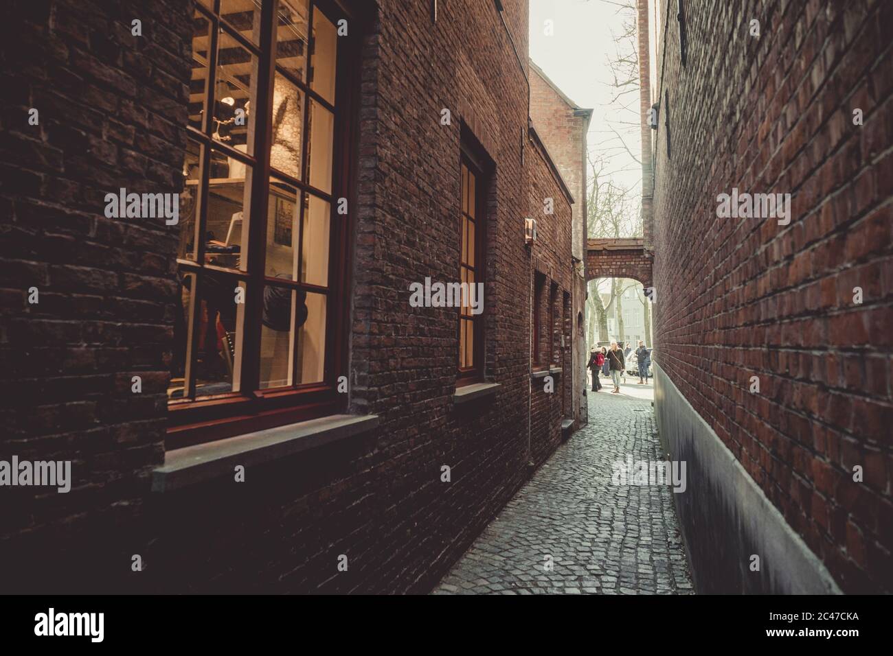 Alleyway with glass windows and a brick wall of a building Stock Photo ...