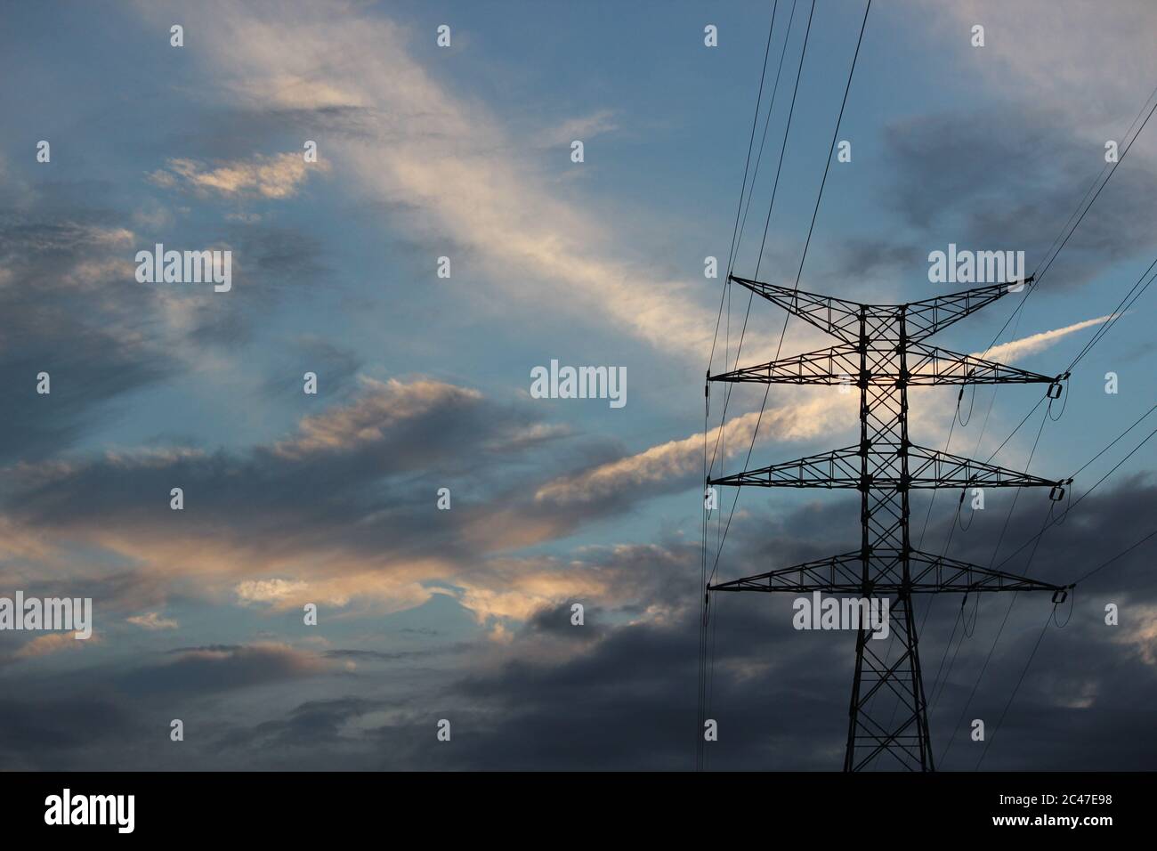 Electrical tower connected to cords under the clouded sky Stock Photo ...