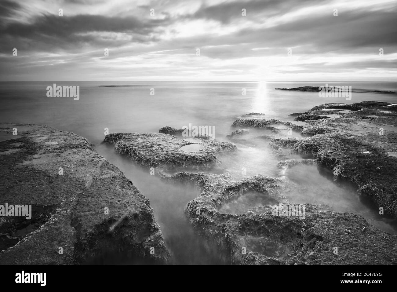 Greyscale shot of the sunset over the sea Stock Photo - Alamy