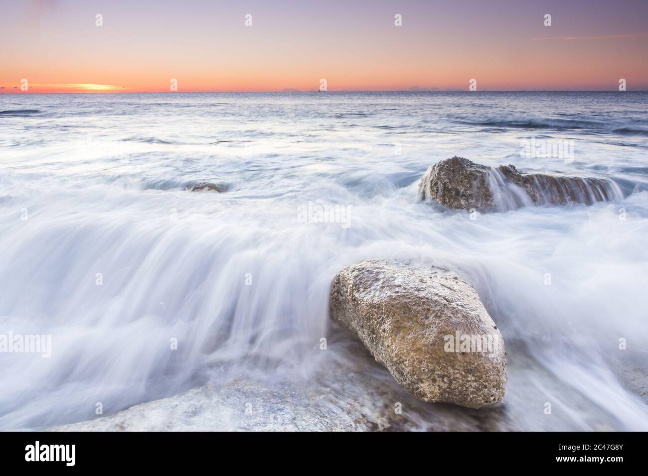 Rocks surrounded by the sea with long exposure during a beautiful ...