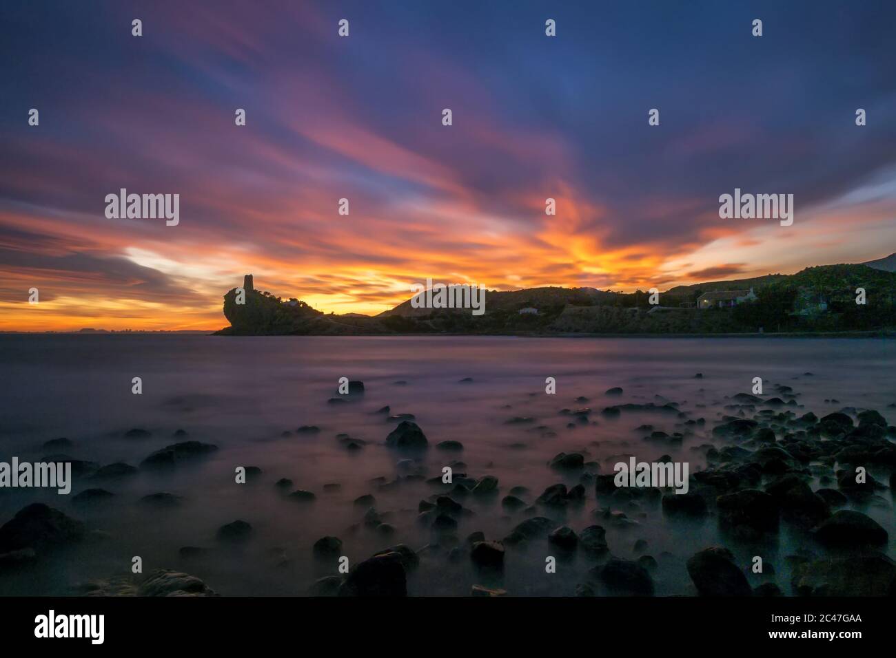 Beautiful view of the calm sea and rocks during sunset Stock Photo - Alamy