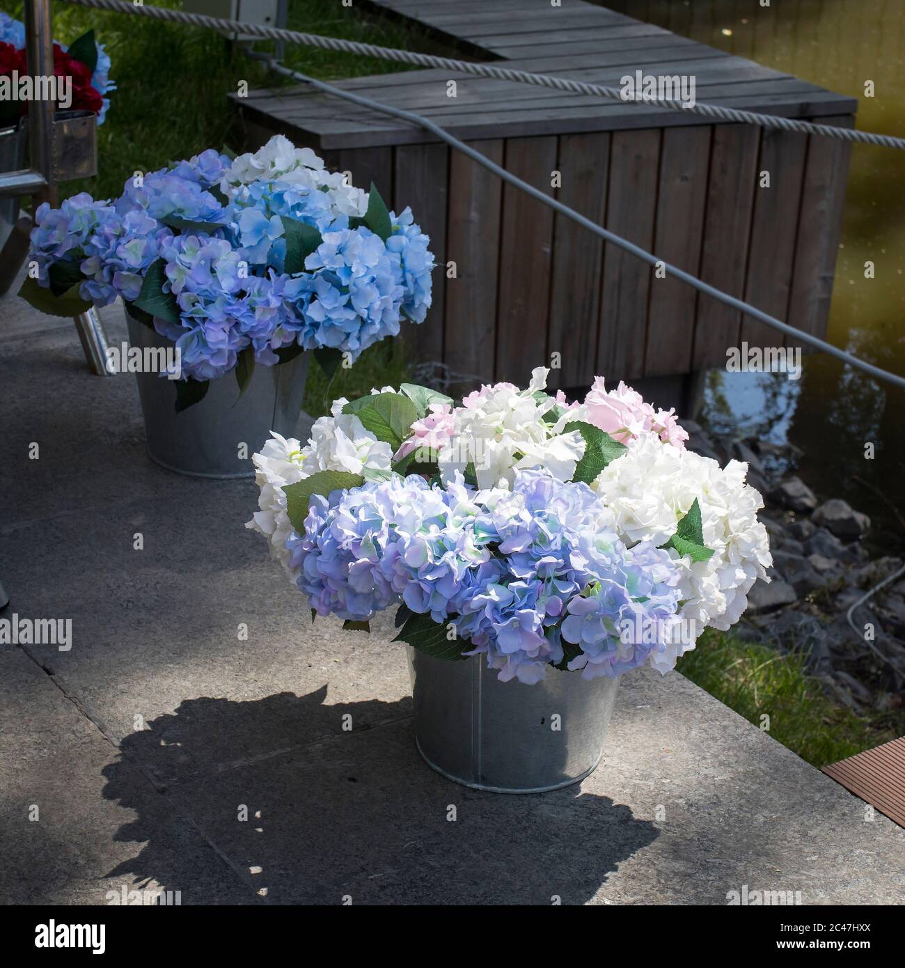 Artificial white and blue hydrangeas in aluminum buckets adorn the ...