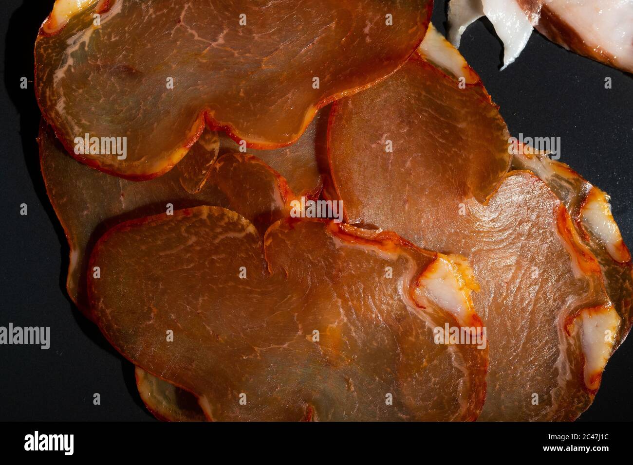 Closeup shot of thin-sliced raw pork meat on a black surface Stock ...