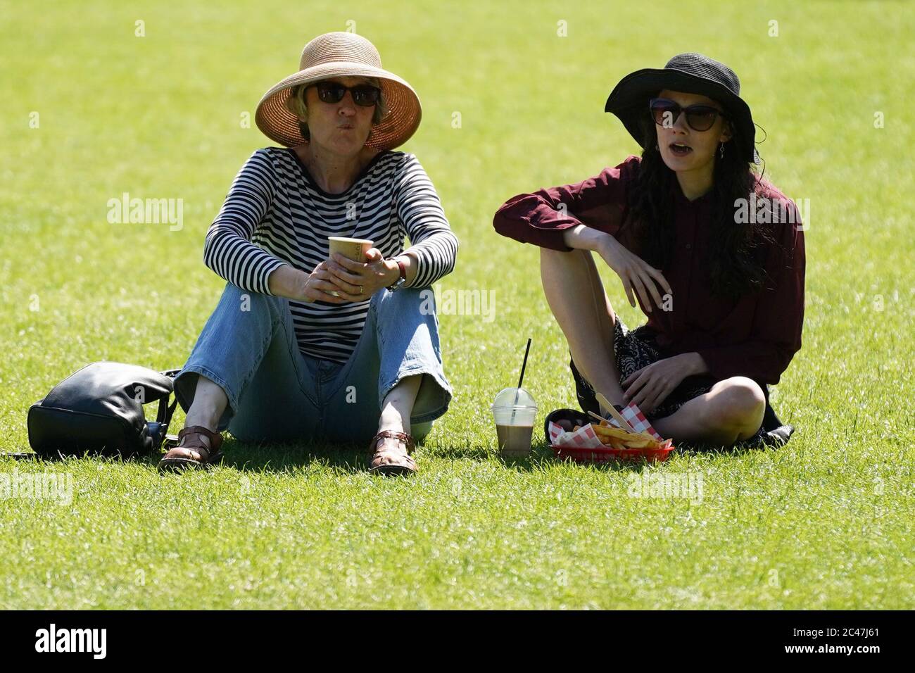 Sheffield, UK. 23rd June, 2020. Women relax under the sun in Endcliffe ...