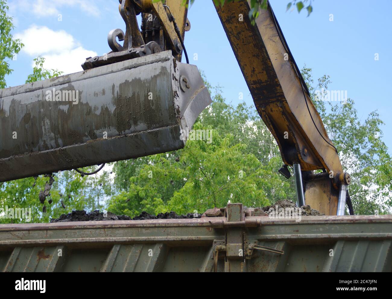 Excavator load soil on truck. Digger machine on construction site ...
