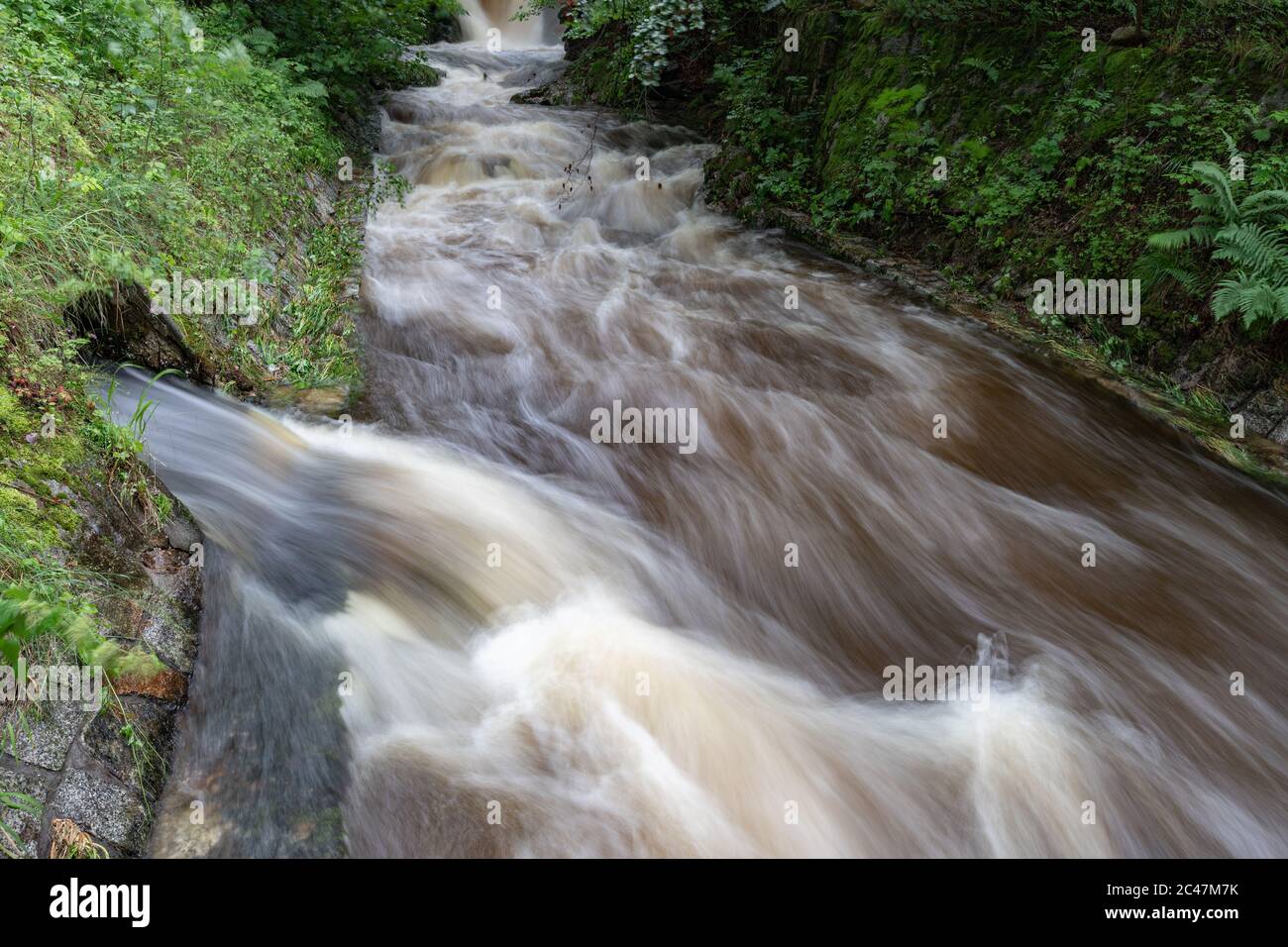 The outflow leading to the regulated river. Rapid river in a mountain ...