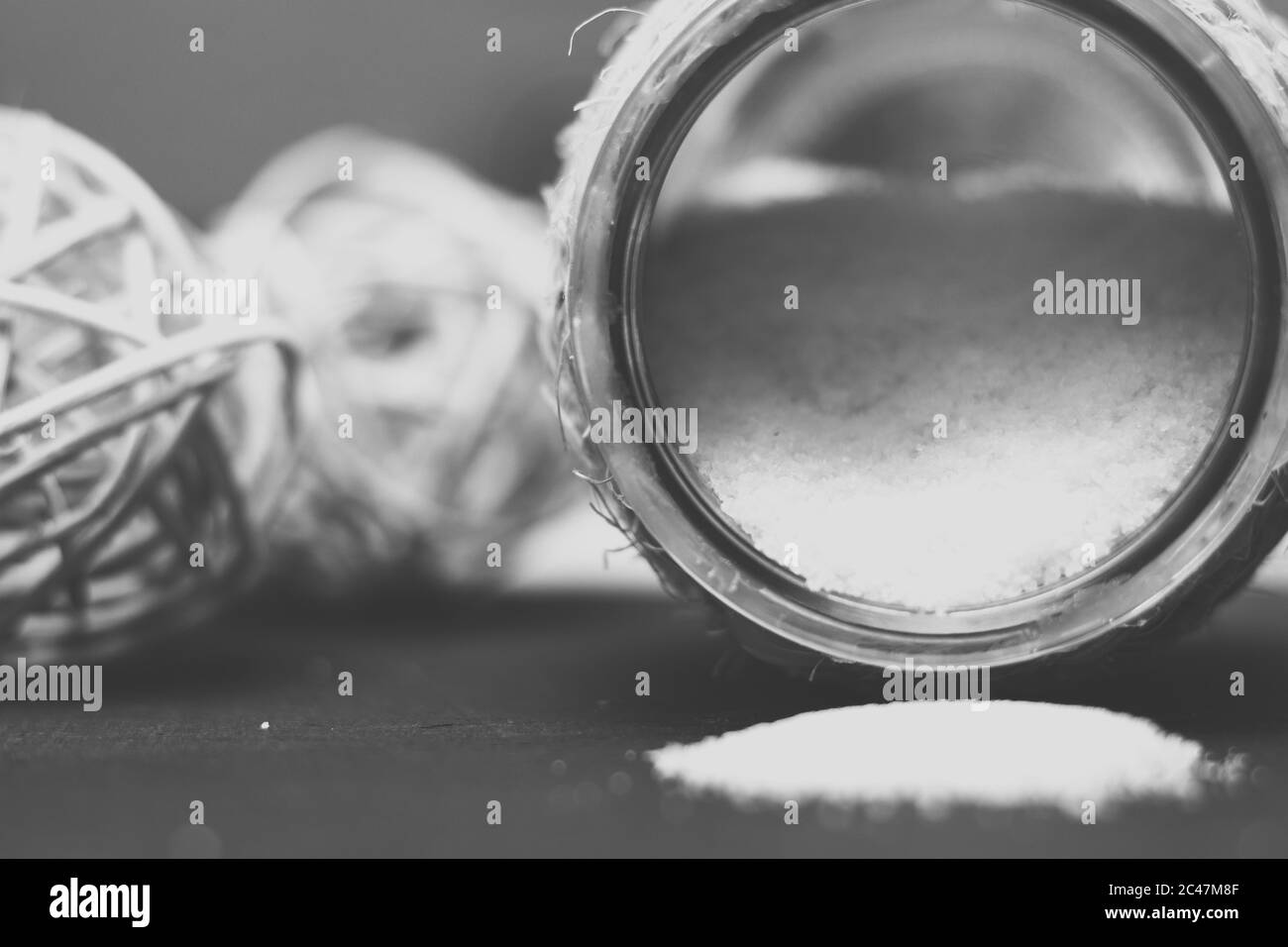 Greyscale shot of a salt shaker and sprinkled salt Stock Photo - Alamy