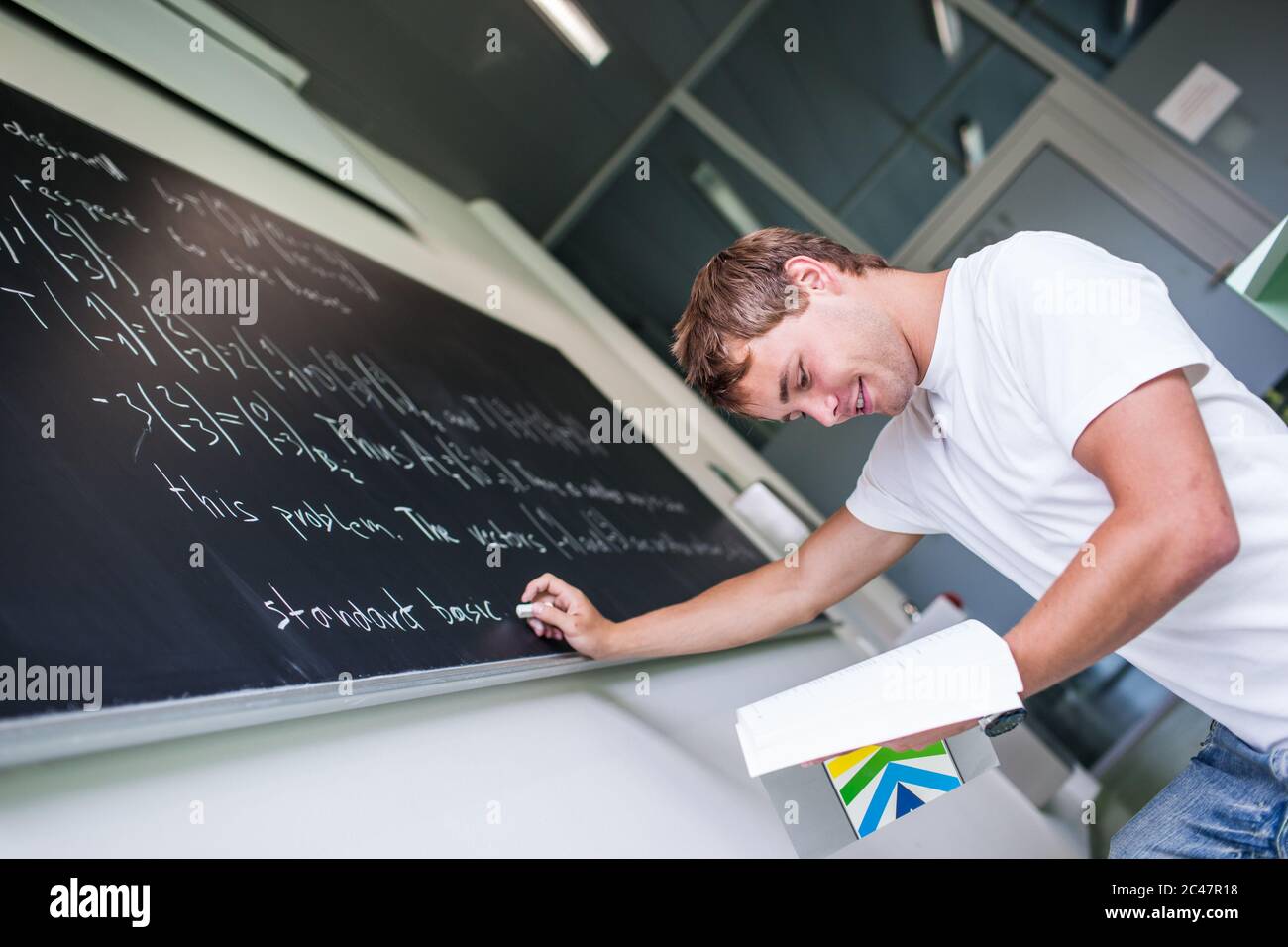 Handsome college student solving a math problem during math class in ...