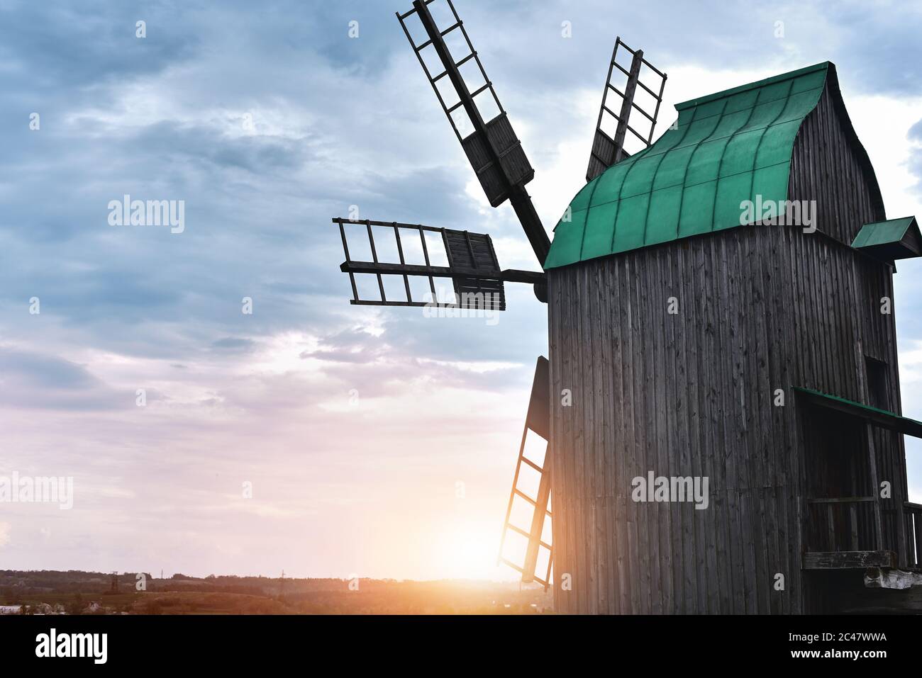 Old windmill standing alone in the field with the blue sky on the ...