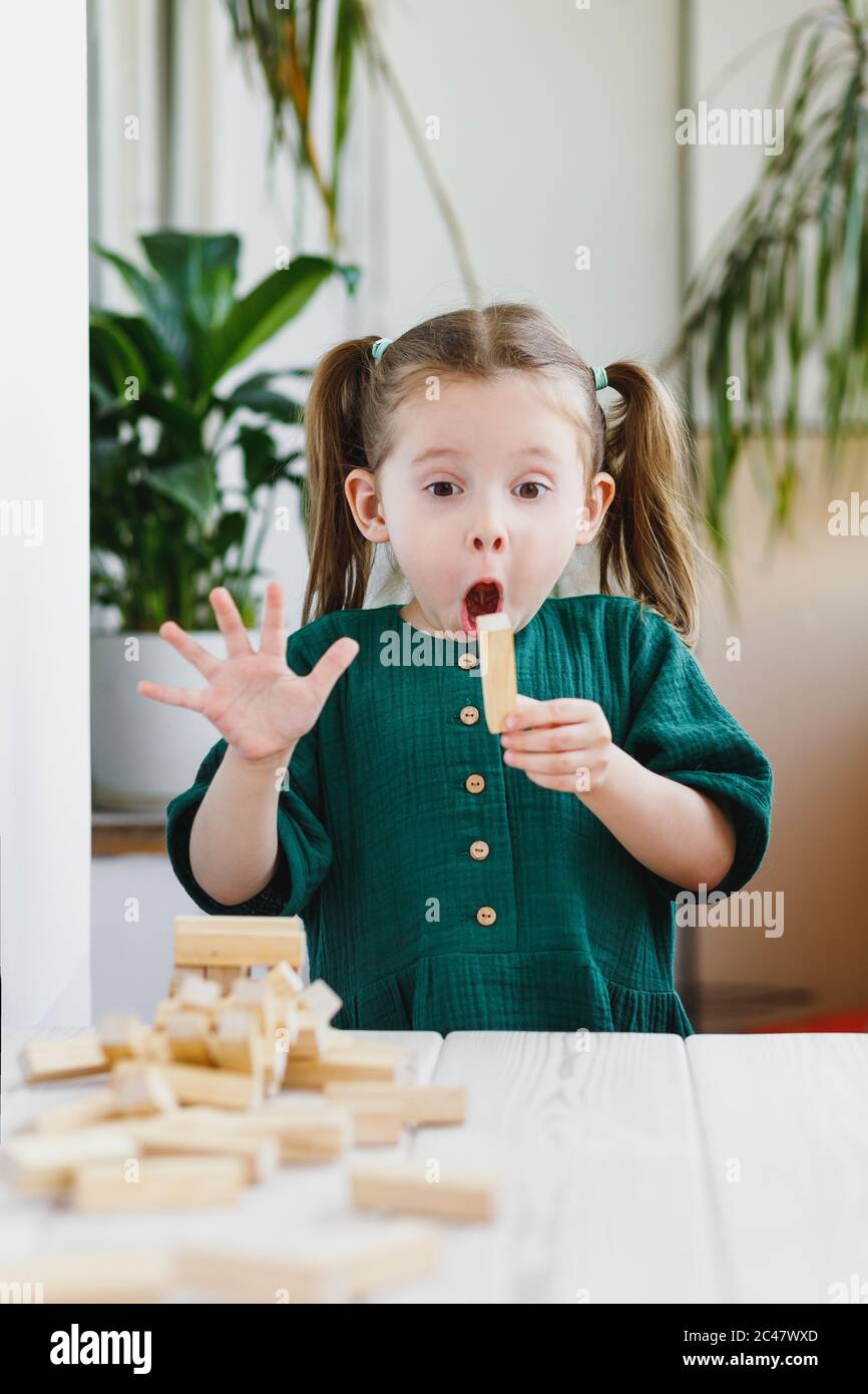 Preschool age girl expressive reaction on unexpected falling of wooden ...