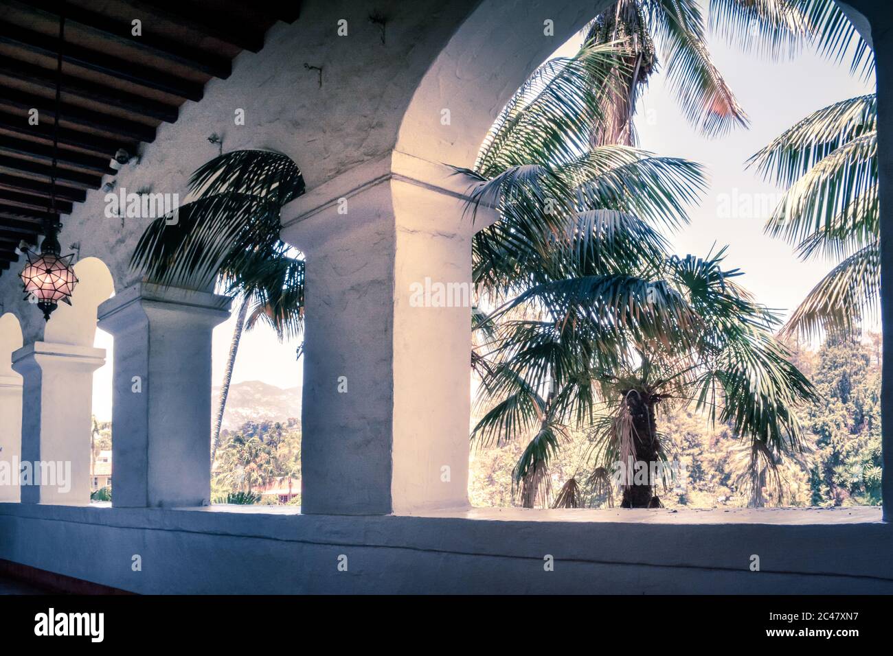 View of garden below from Spanish Moorish style colonnade with arches ...