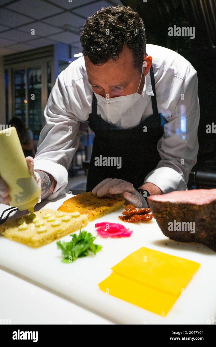 Vertical shot of a male chef wearing a face mask preparing a delicious ...