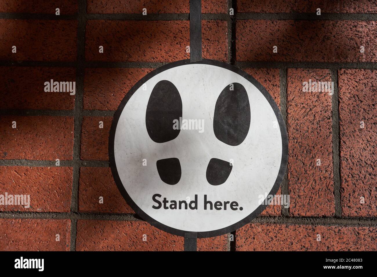 Social distancing footprint marker on the sidewalk outside a retail ...