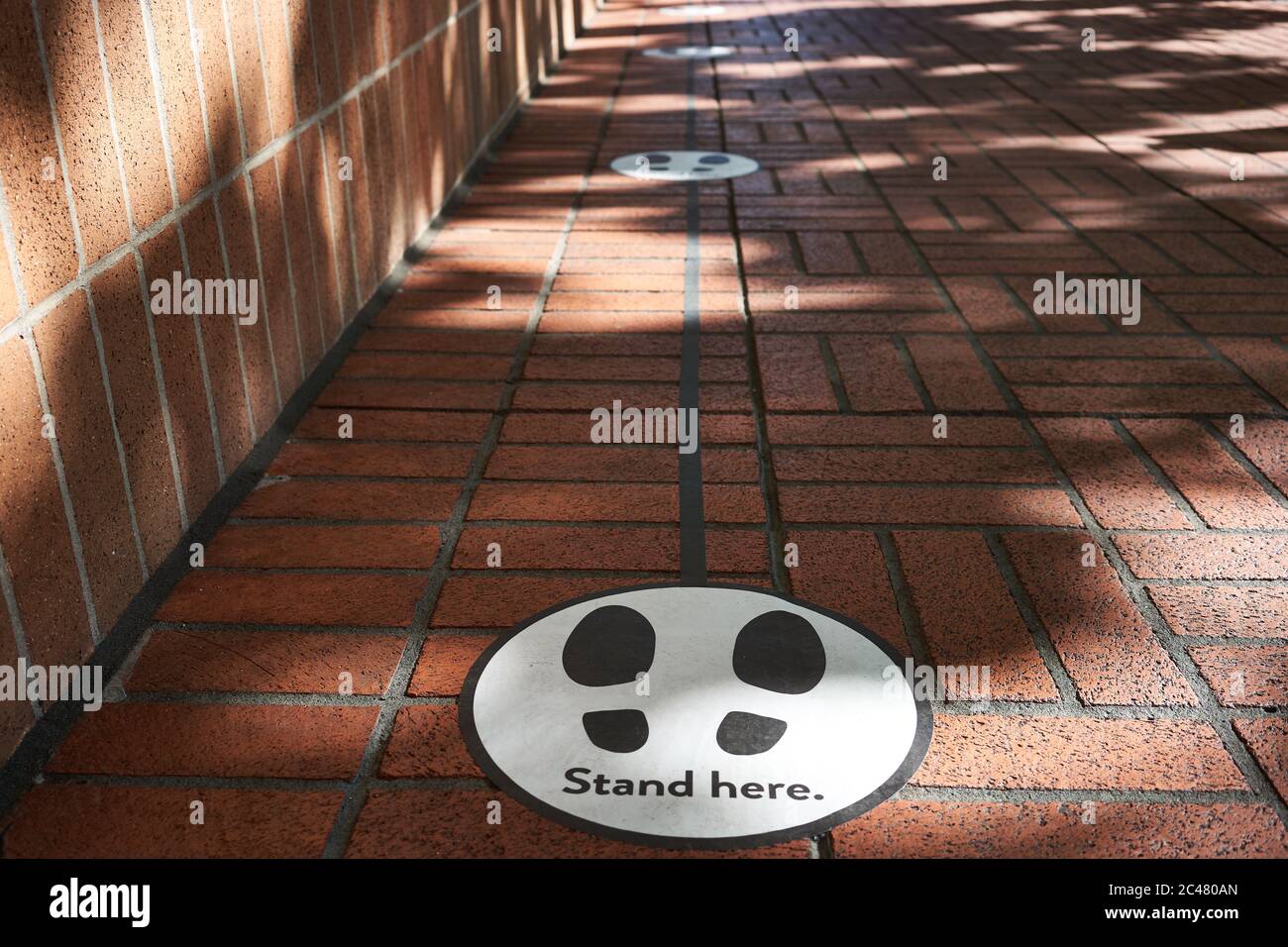 Social distancing footprint markers on the sidewalk outside a retail ...