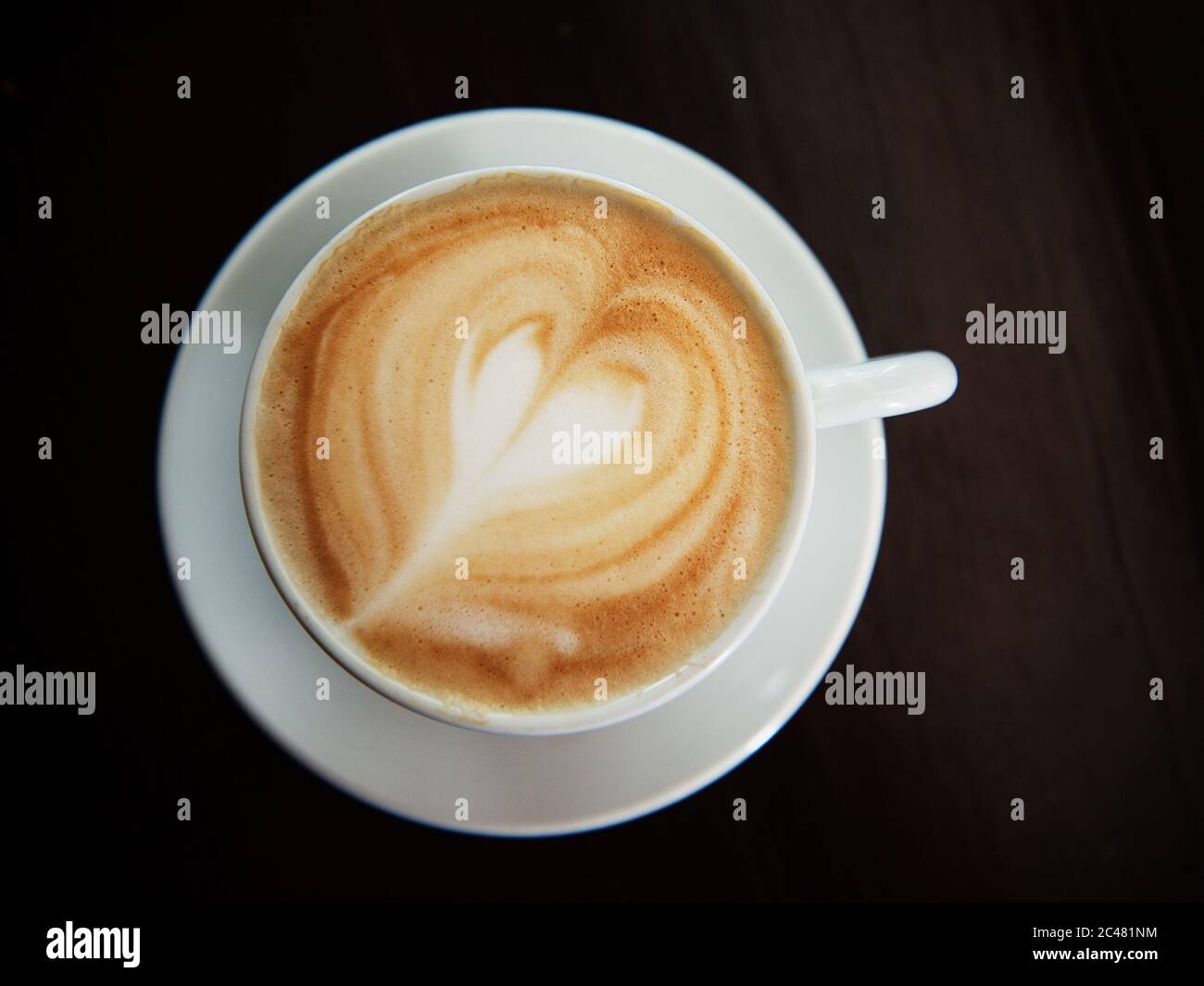 Latte on a dark wood background Stock Photo - Alamy