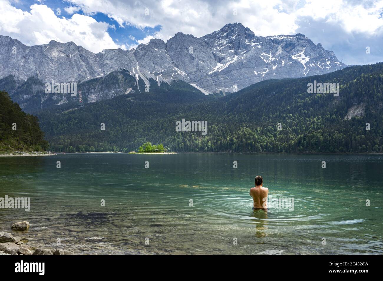 Person swimming in Eibsee lake in Germany in front of the mountains ...