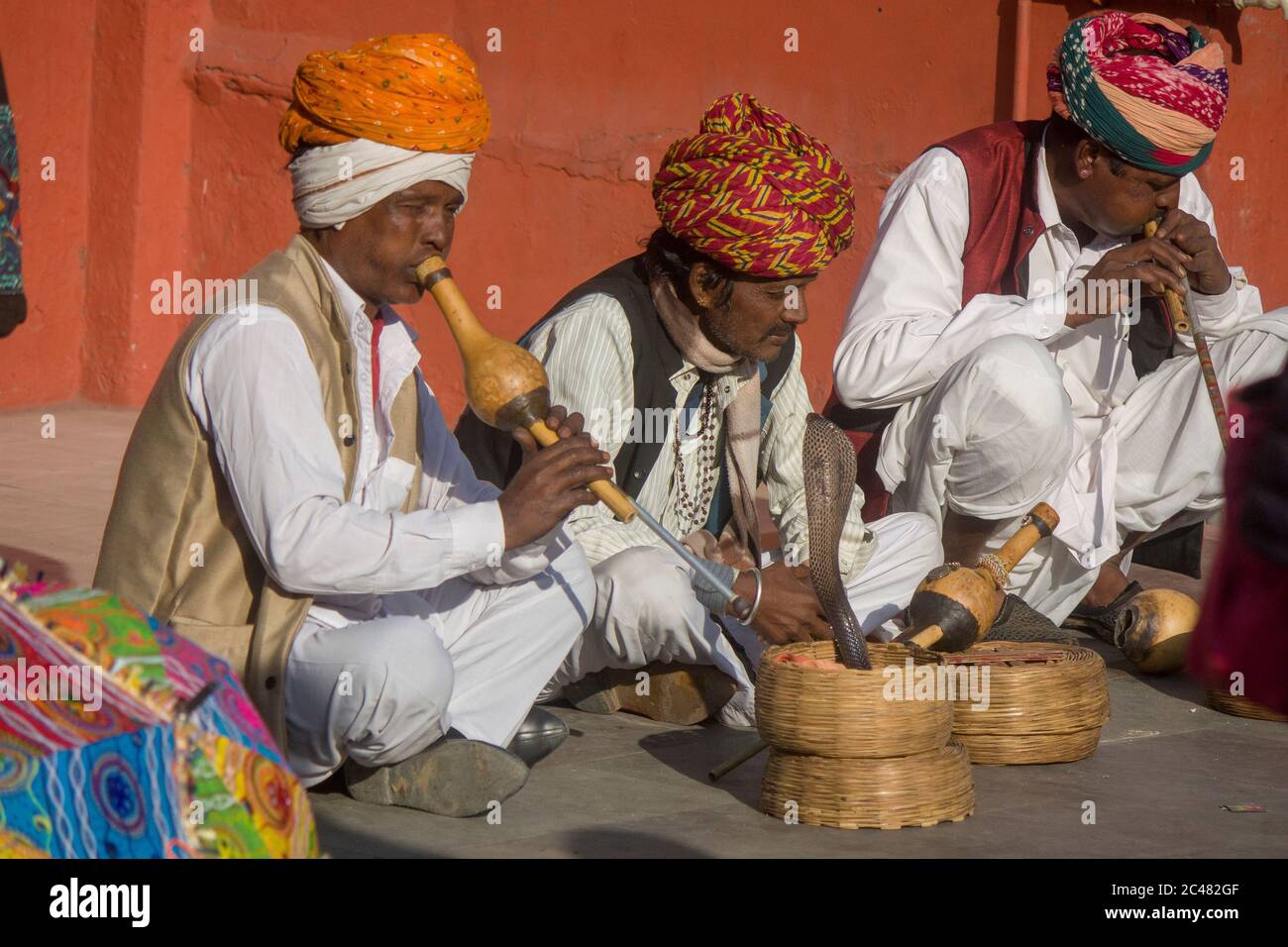 Snake charmers are playing and waving around an instrument called a ...