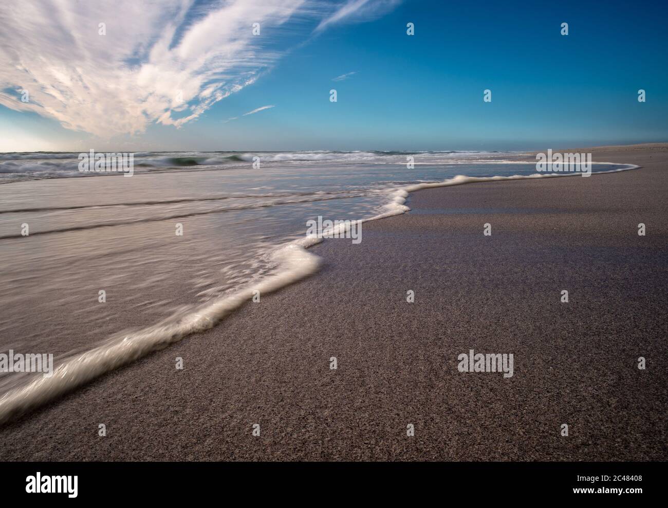 Beach surrounded by the sea with long exposure under the sunlight at ...