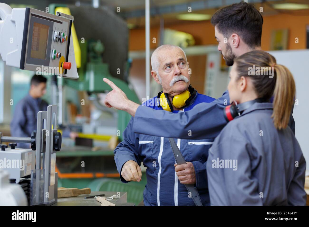 young industrial engineers pointing at a machine Stock Photo - Alamy
