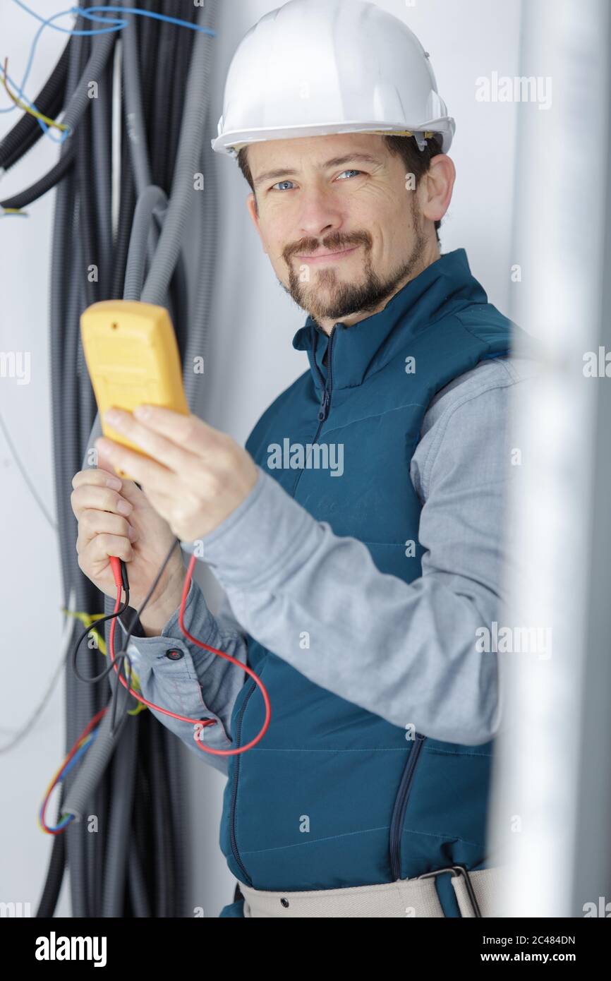 electrician measuring voltage of cable on ceiling indoors Stock Photo ...