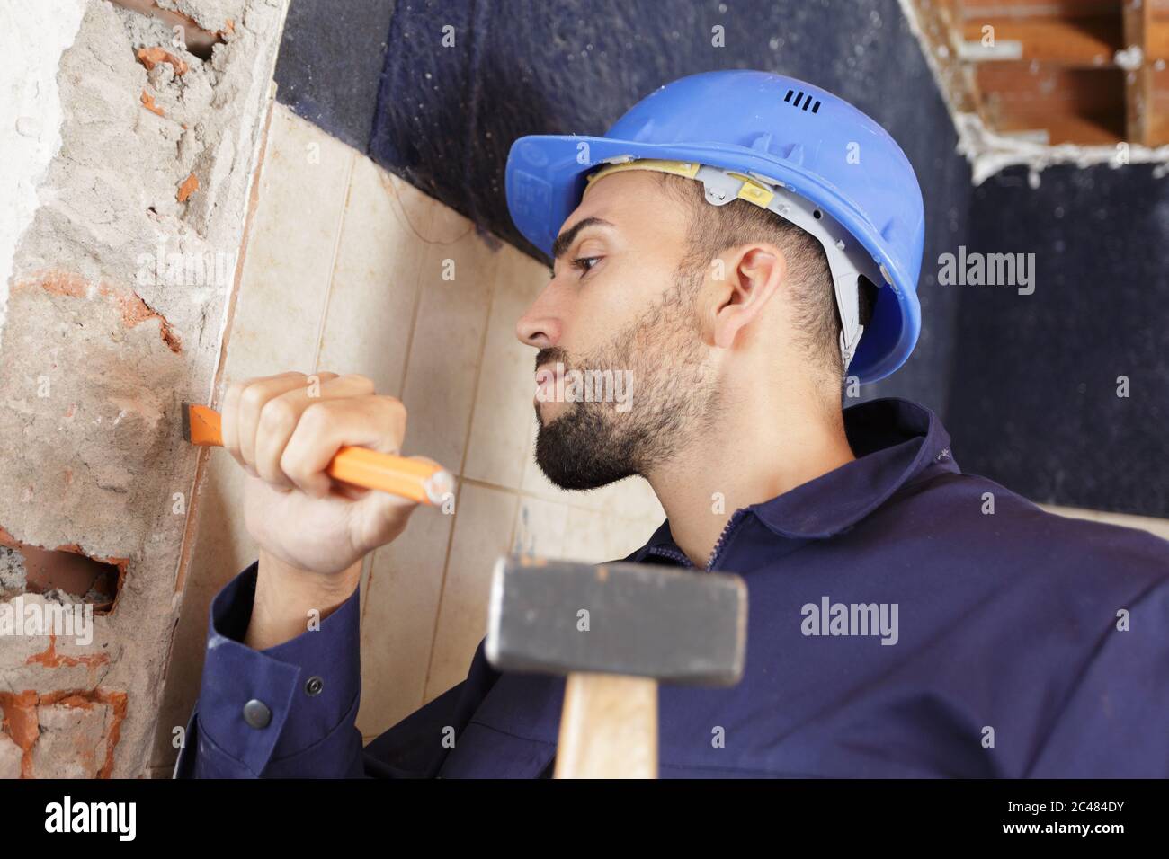 concentrated builder breaking a wall Stock Photo - Alamy