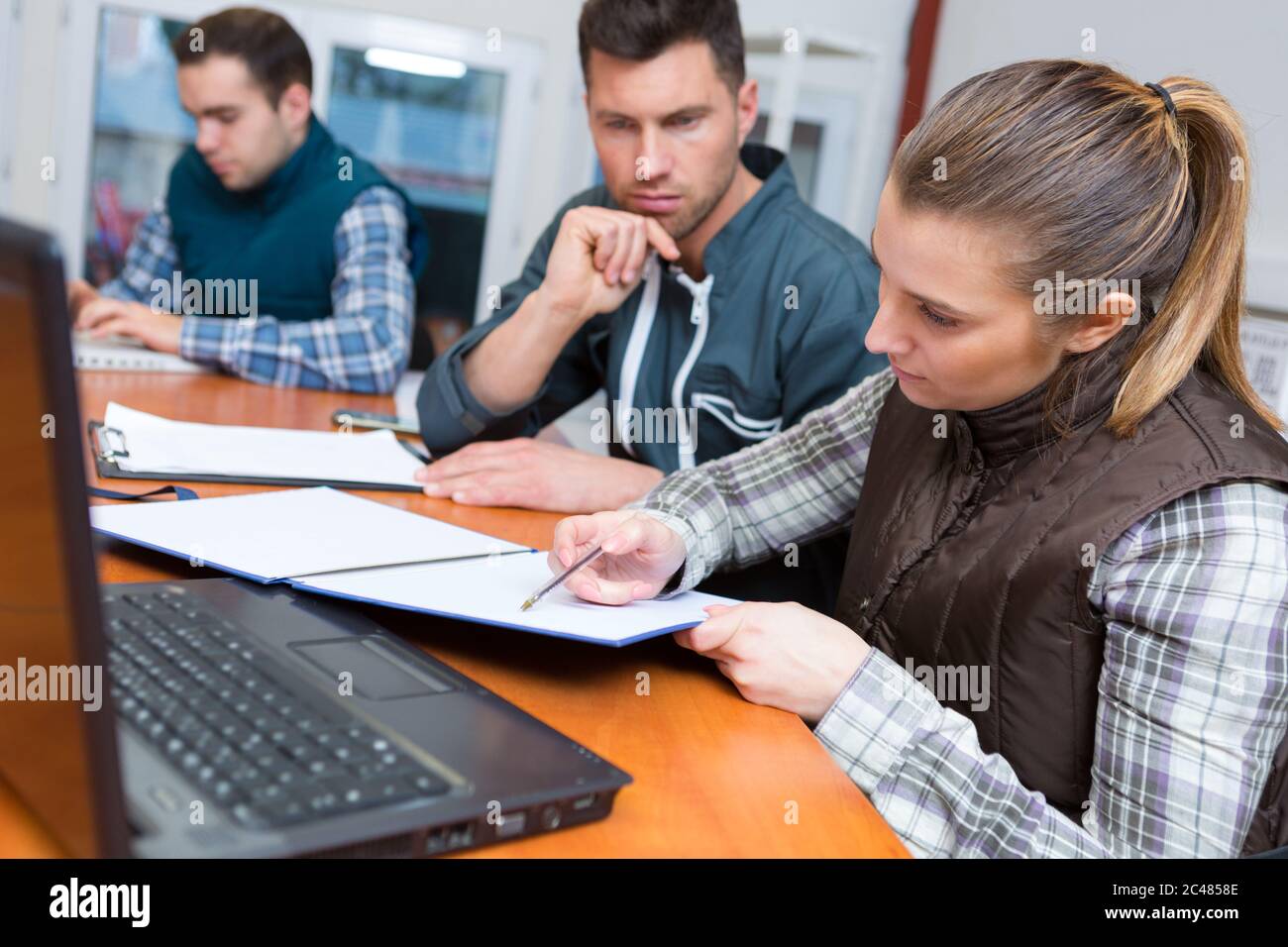blue-collar workers sat around a desk Stock Photo - Alamy