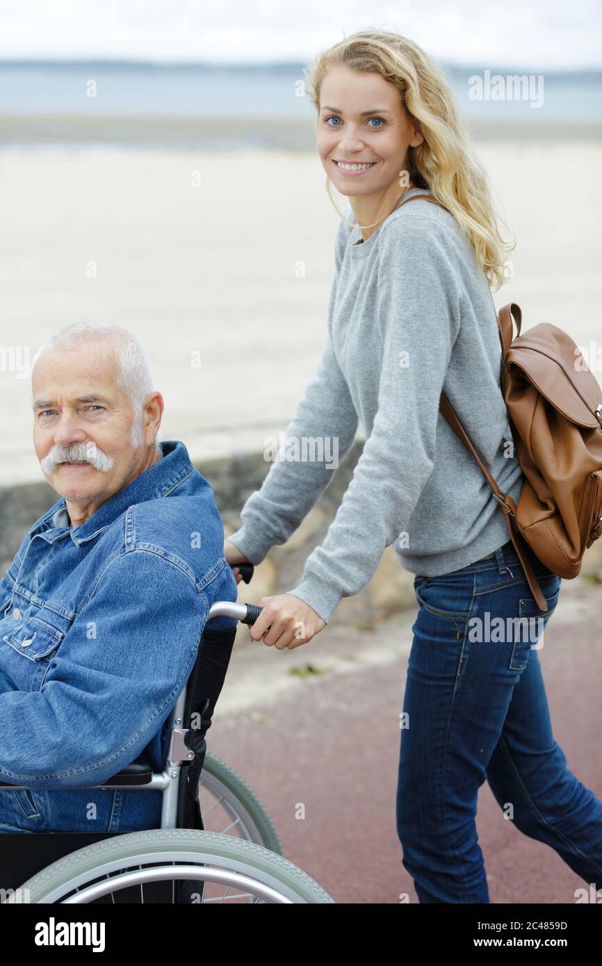 adult daughter pushing her senior father in his wheelchair Stock Photo ...