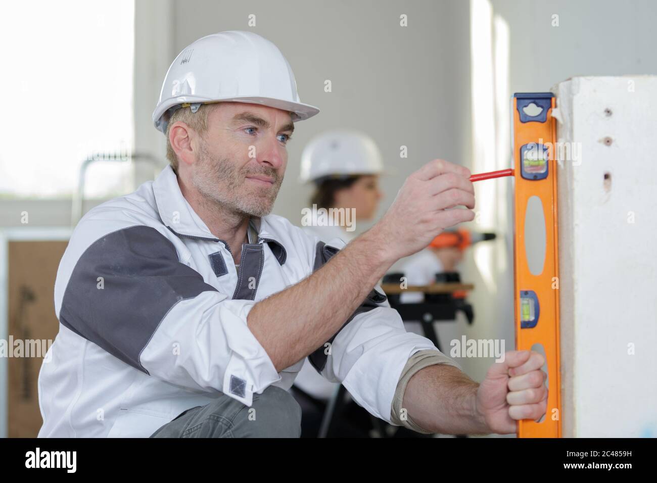 builder measuring wall with level Stock Photo - Alamy