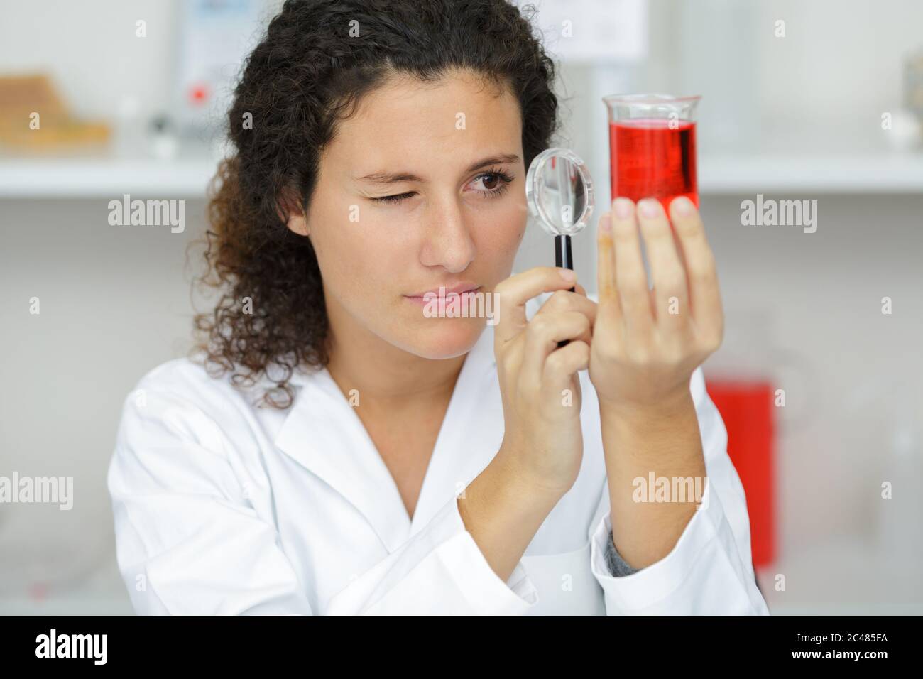 woman looking at test tube Stock Photo - Alamy