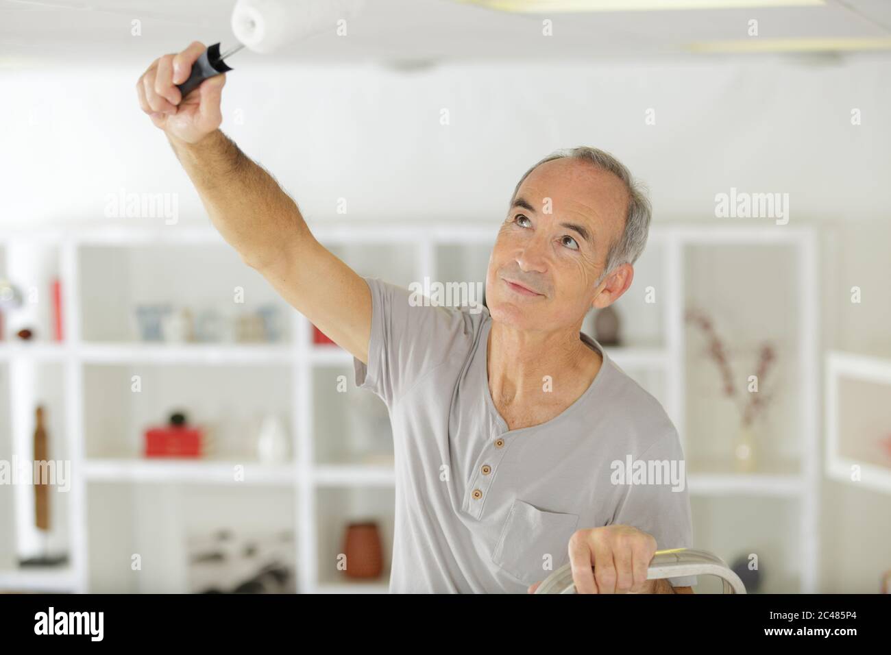 a man painting the ceiling Stock Photo - Alamy