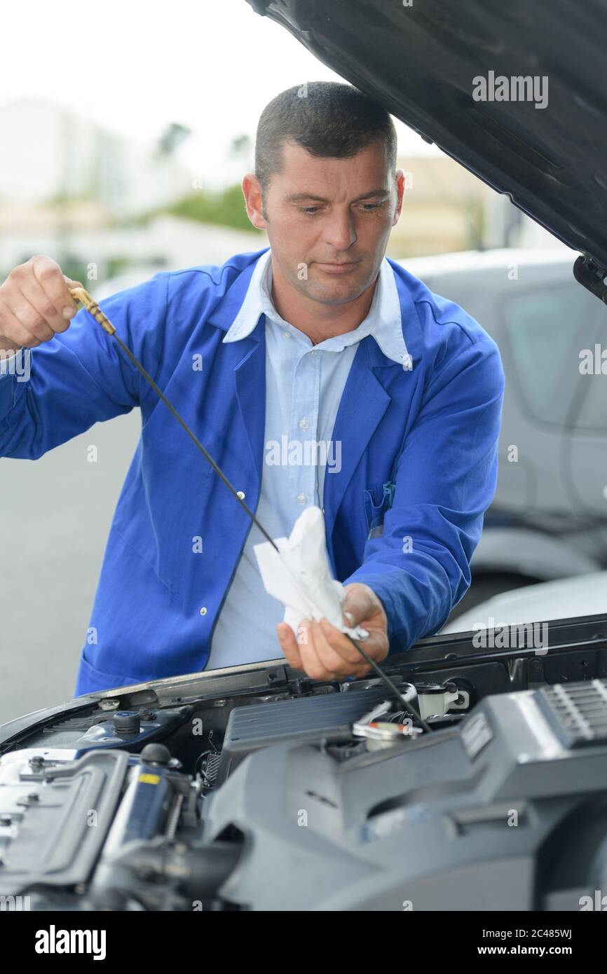mechanic hand checking oil level Stock Photo - Alamy