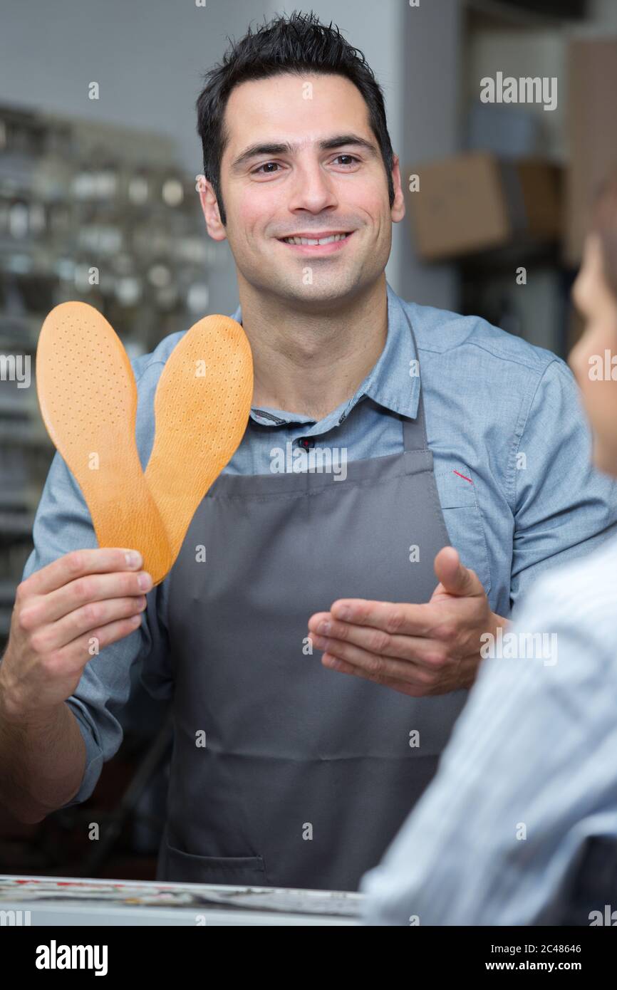 happy shoe worker holding shoes soles Stock Photo - Alamy