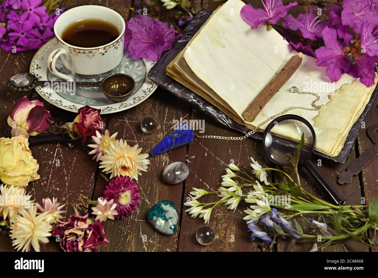 Still life with open diary book, cup of coffee and crystal stone on ...