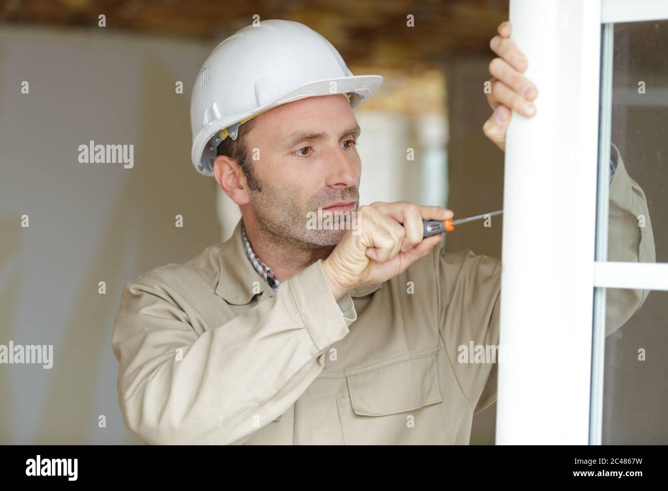 a mature handyman repair window Stock Photo - Alamy