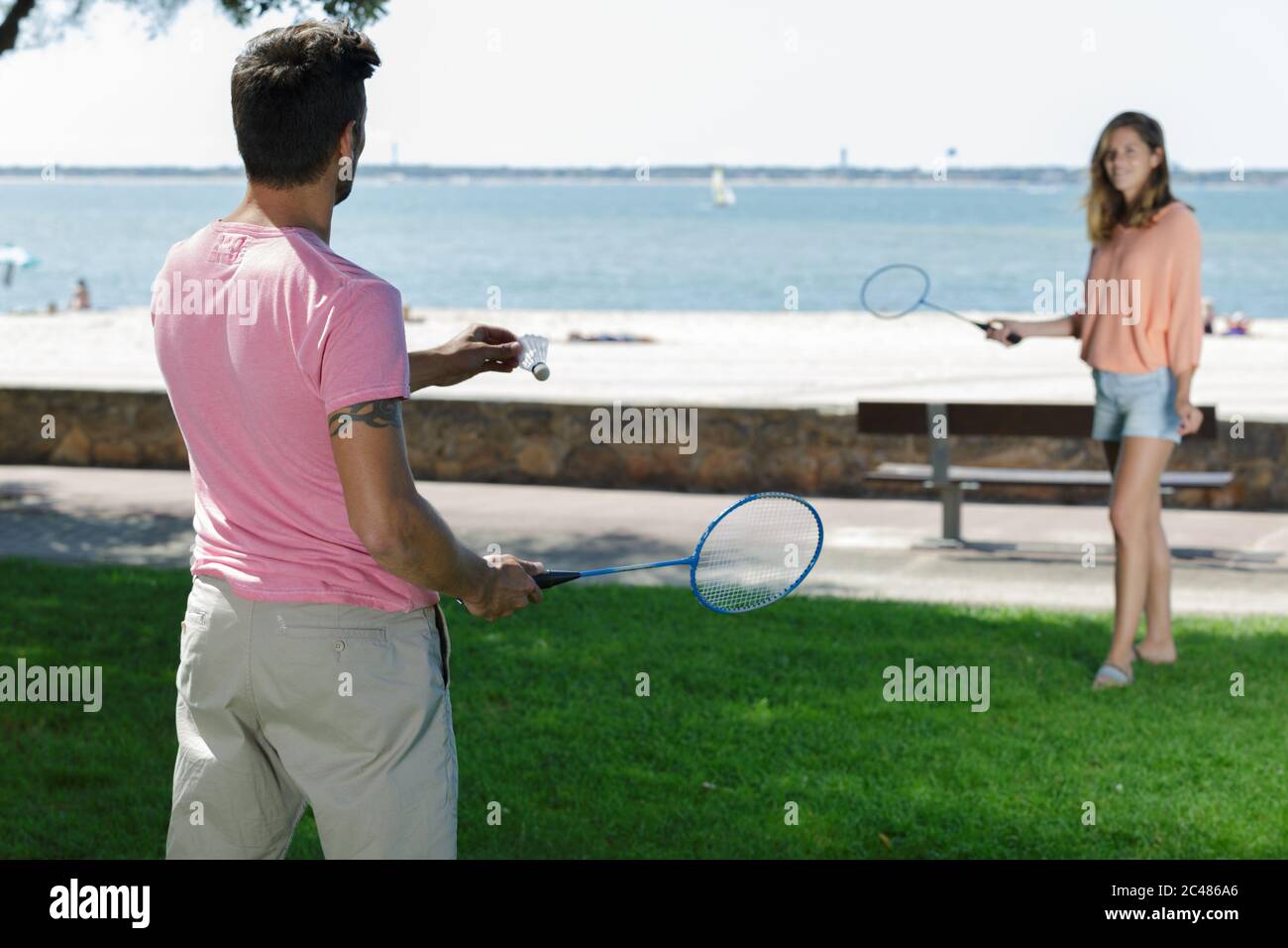 young smiling couple playing badminton Stock Photo - Alamy