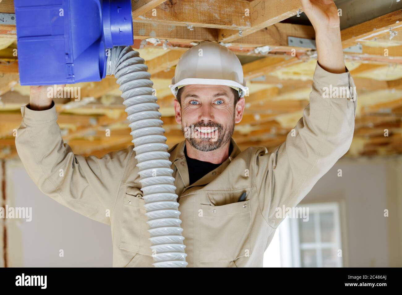 a man during installation of ventilation pipes Stock Photo - Alamy
