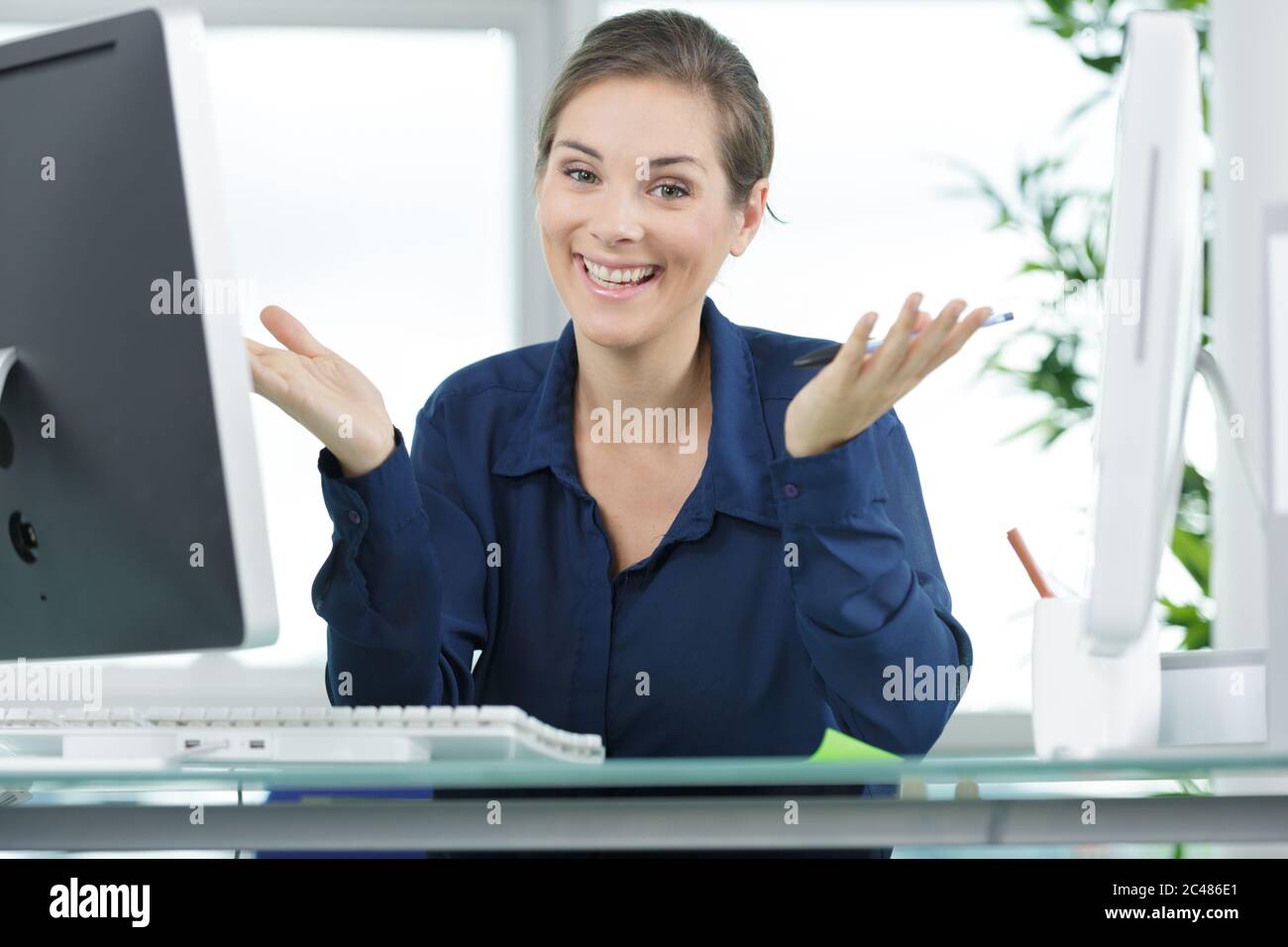 secretary shrugging at her desk Stock Photo - Alamy