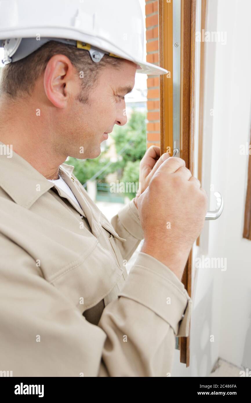 handyman using screwdriver to work on door mechanism Stock Photo - Alamy