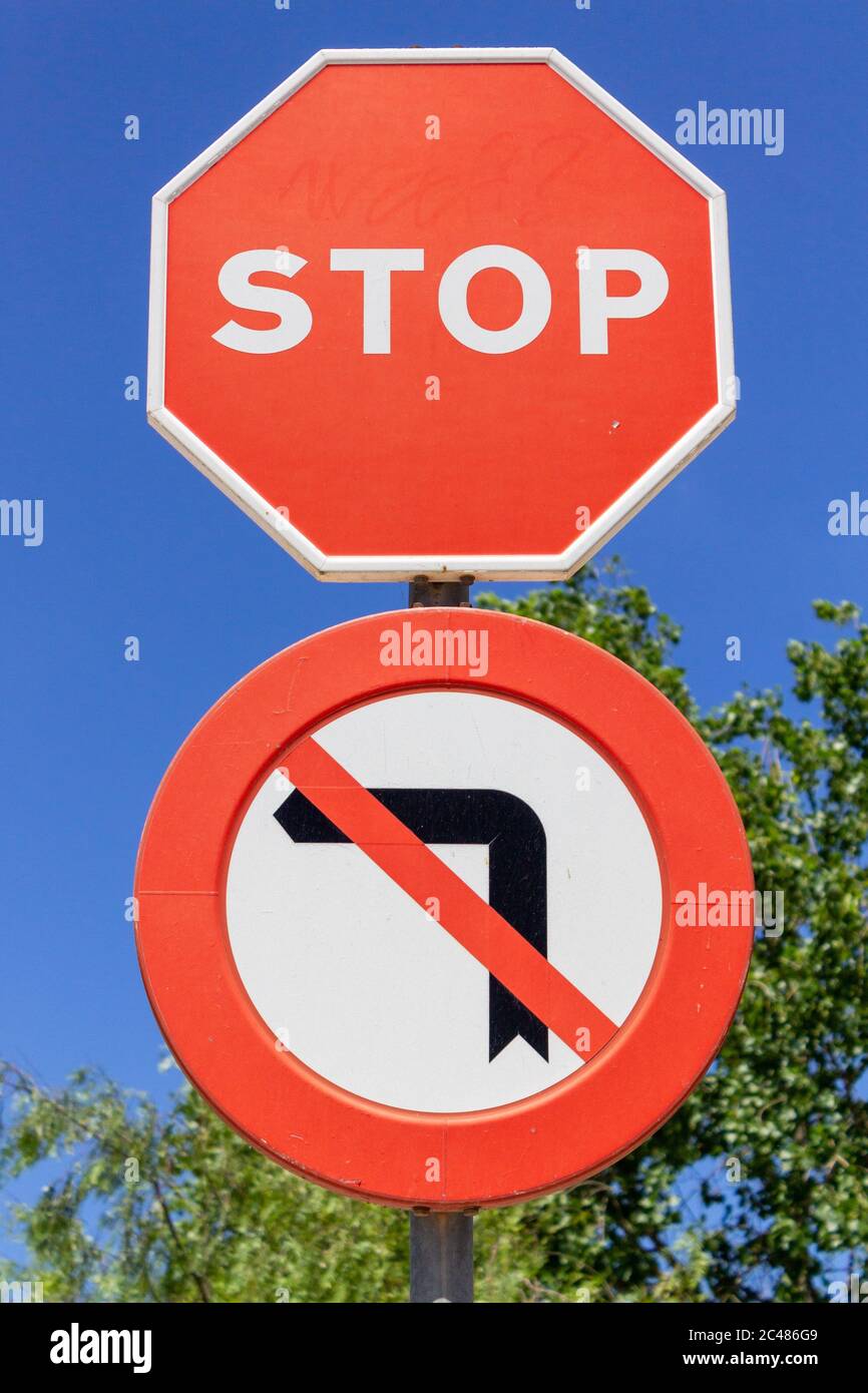 Vertical shot of stop no entry and no left turn road signs in the ...