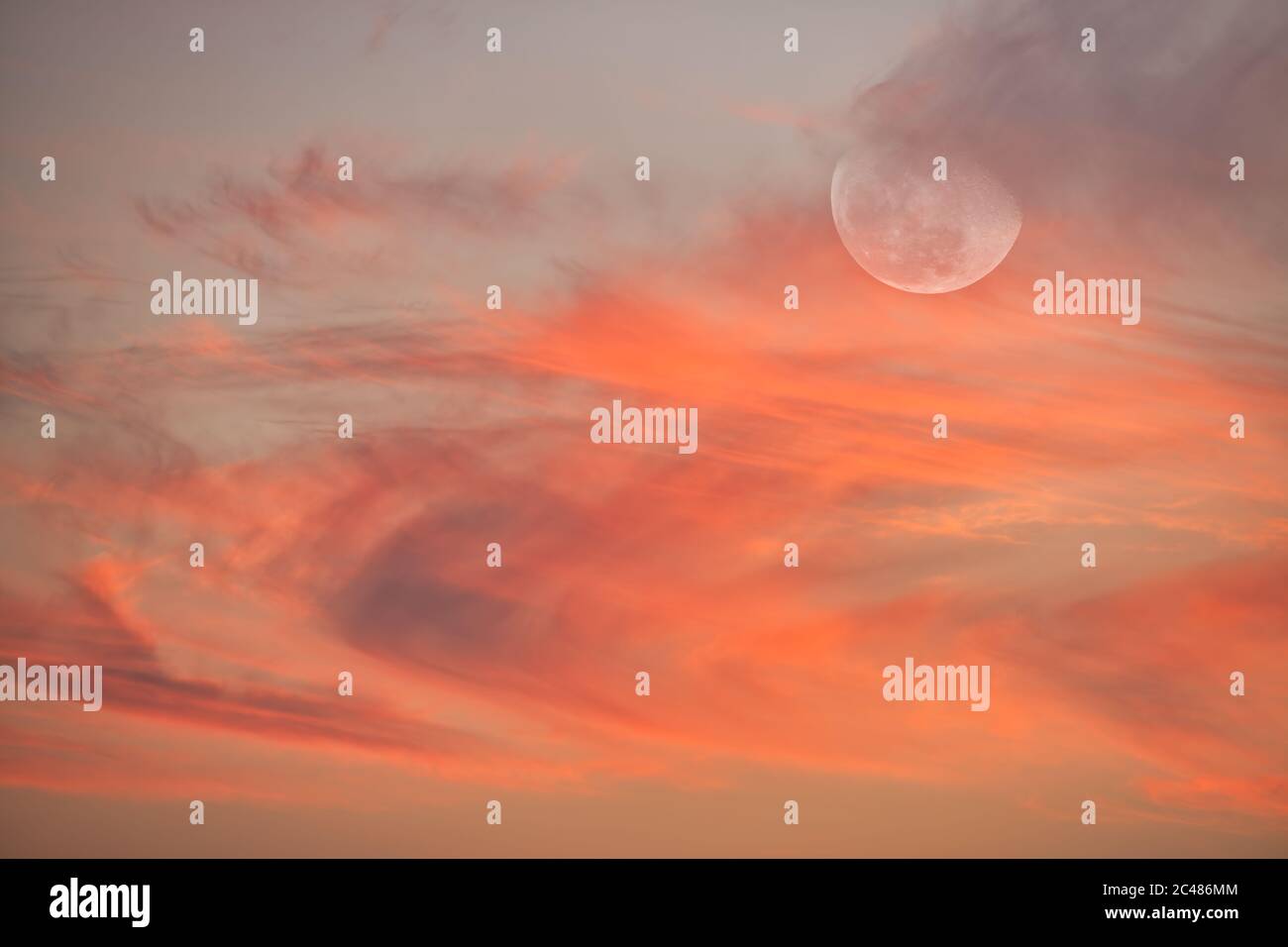 The moon Rises in the Sky Surrounded by a Red Cloud Sunset Sky Stock ...