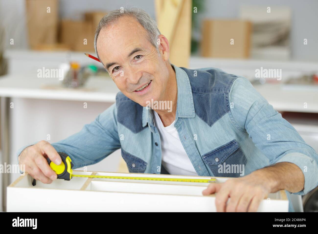 man measuring wood piece for furniture assembling Stock Photo - Alamy