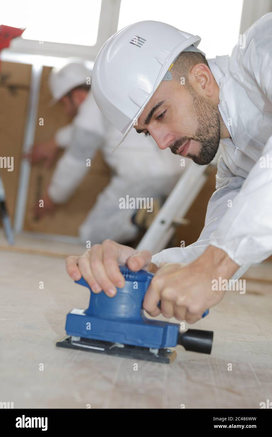 carpenter using a plane wood sander for house construction Stock Photo ...